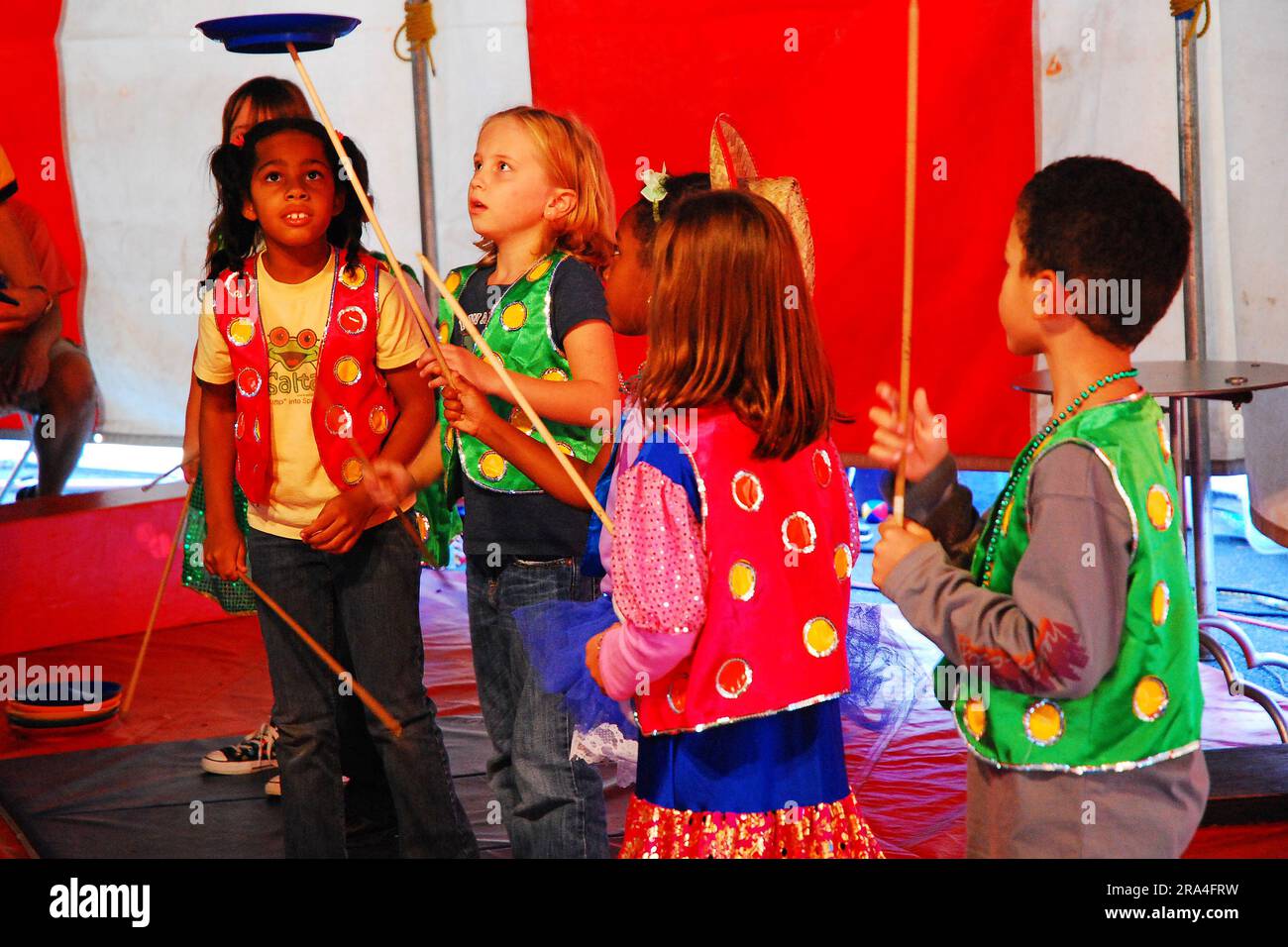 Young children learn to balance spinning plates at a circus and talent ...
