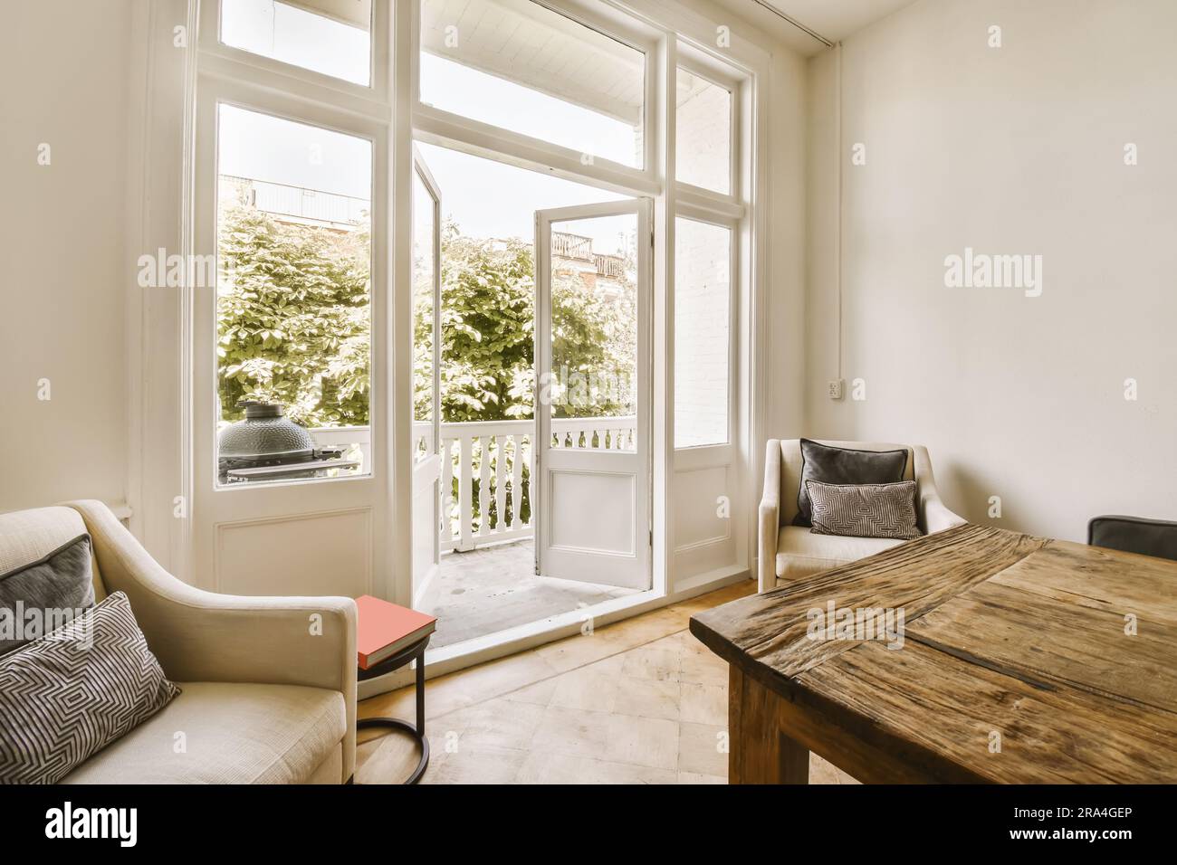 a living room with white walls and wood flooring, there is an open ...