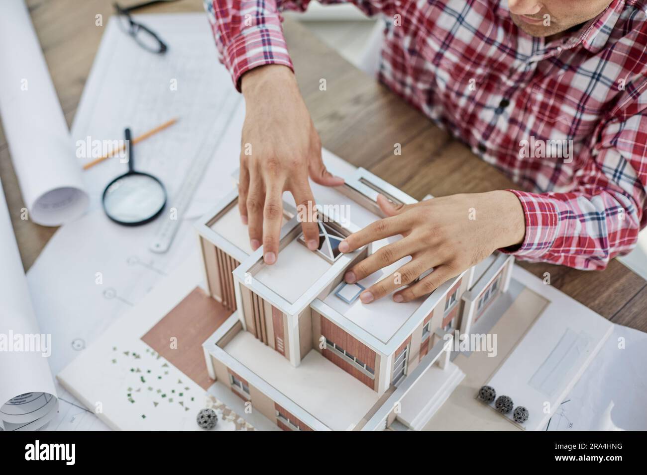 Male architect holding and working on model of architectural house top ...