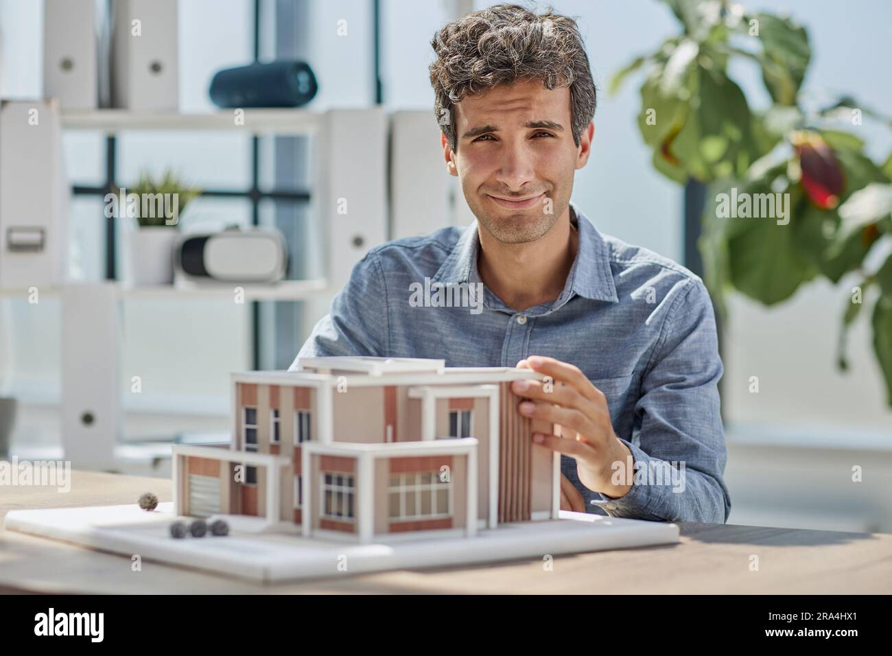 young caucasian engineer man making building model with the use of ...