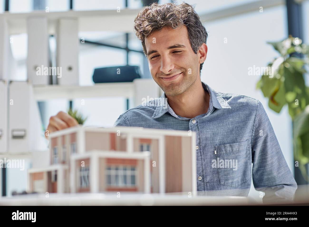young caucasian engineer man making building model with the use of ...