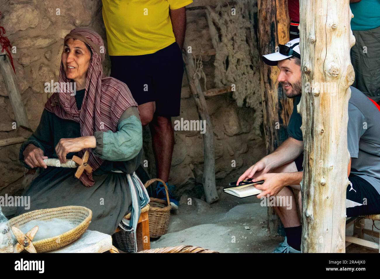 Reenactor Hannah the Weaver demonstrates her craft while a tourist ...