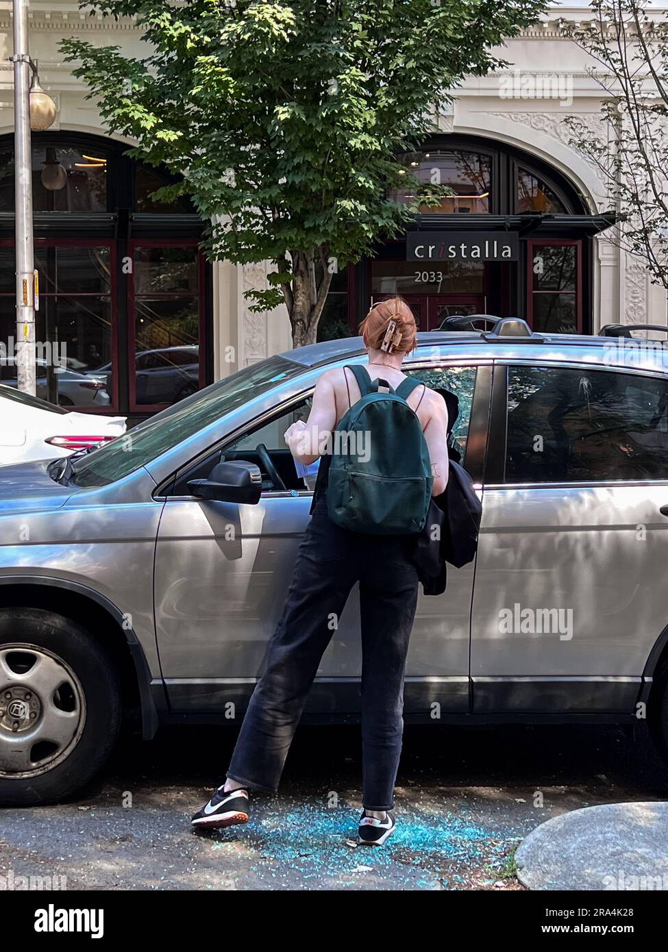 Seattle, USA. 27 Jun, 2023. A woman arriving to her car with a smashed ...