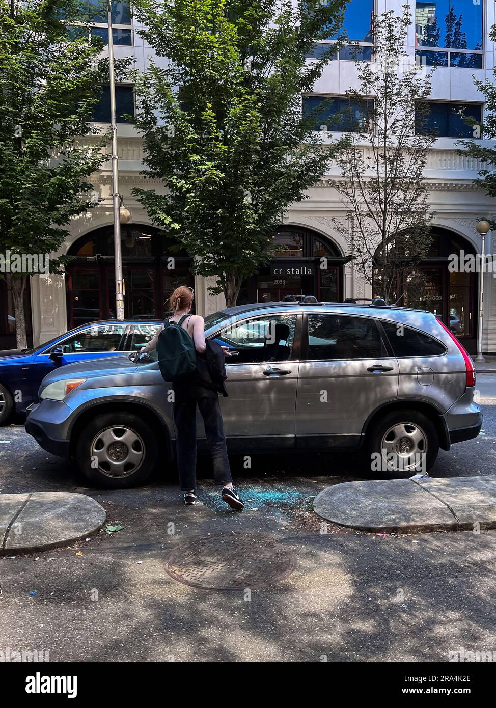 Seattle, USA. 27 Jun, 2023. A woman arriving to her car with a smashed ...