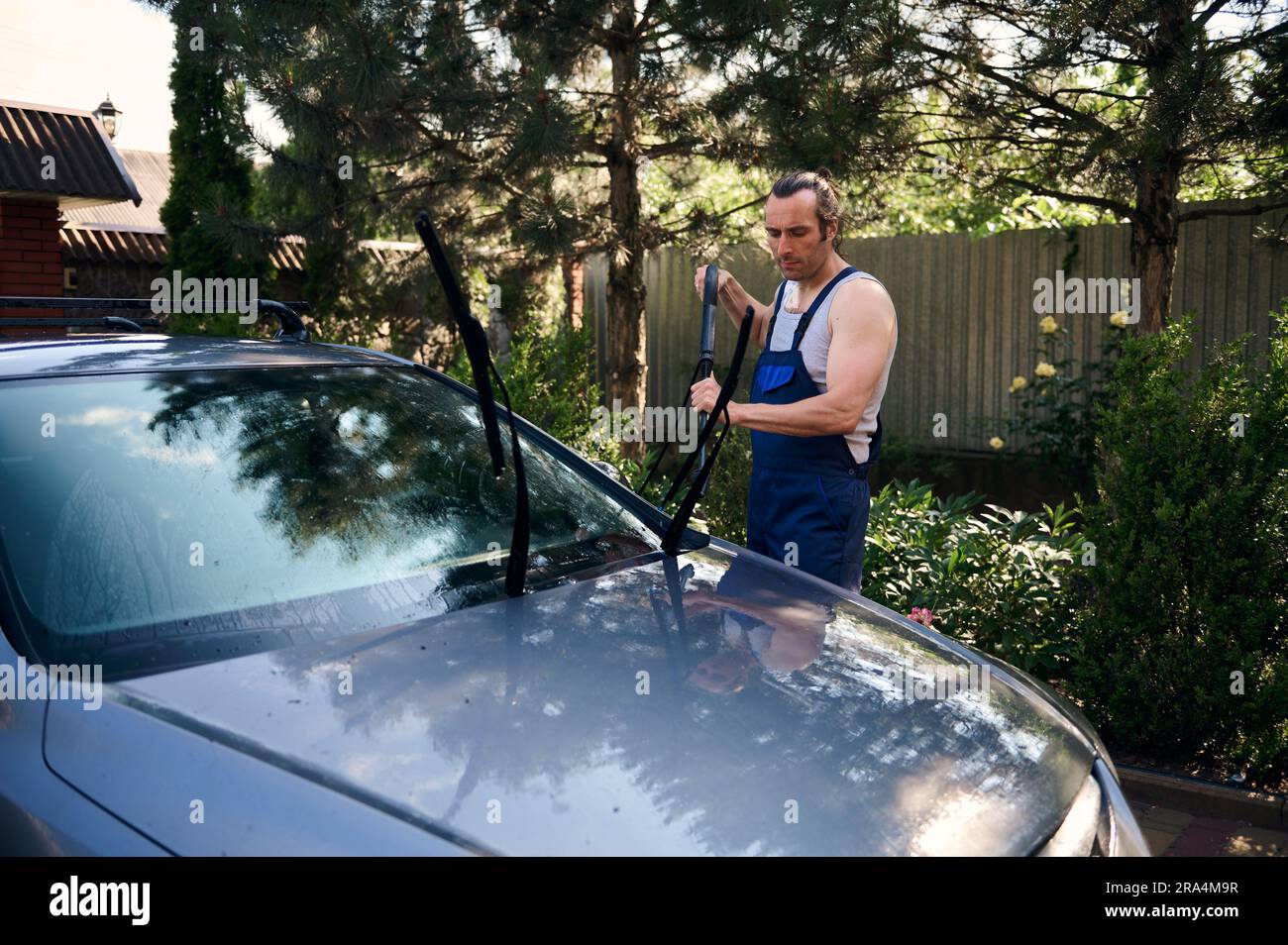 Handsome Caucasian man, car service worker in blue working uniform ...