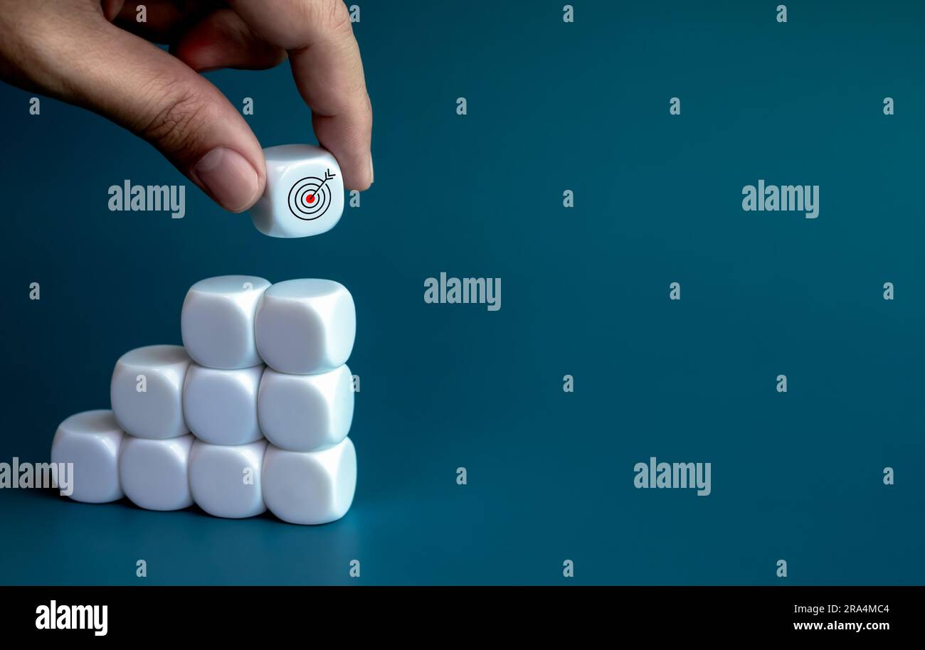 Hand put goal target icon on top of white blocks business chart steps ...