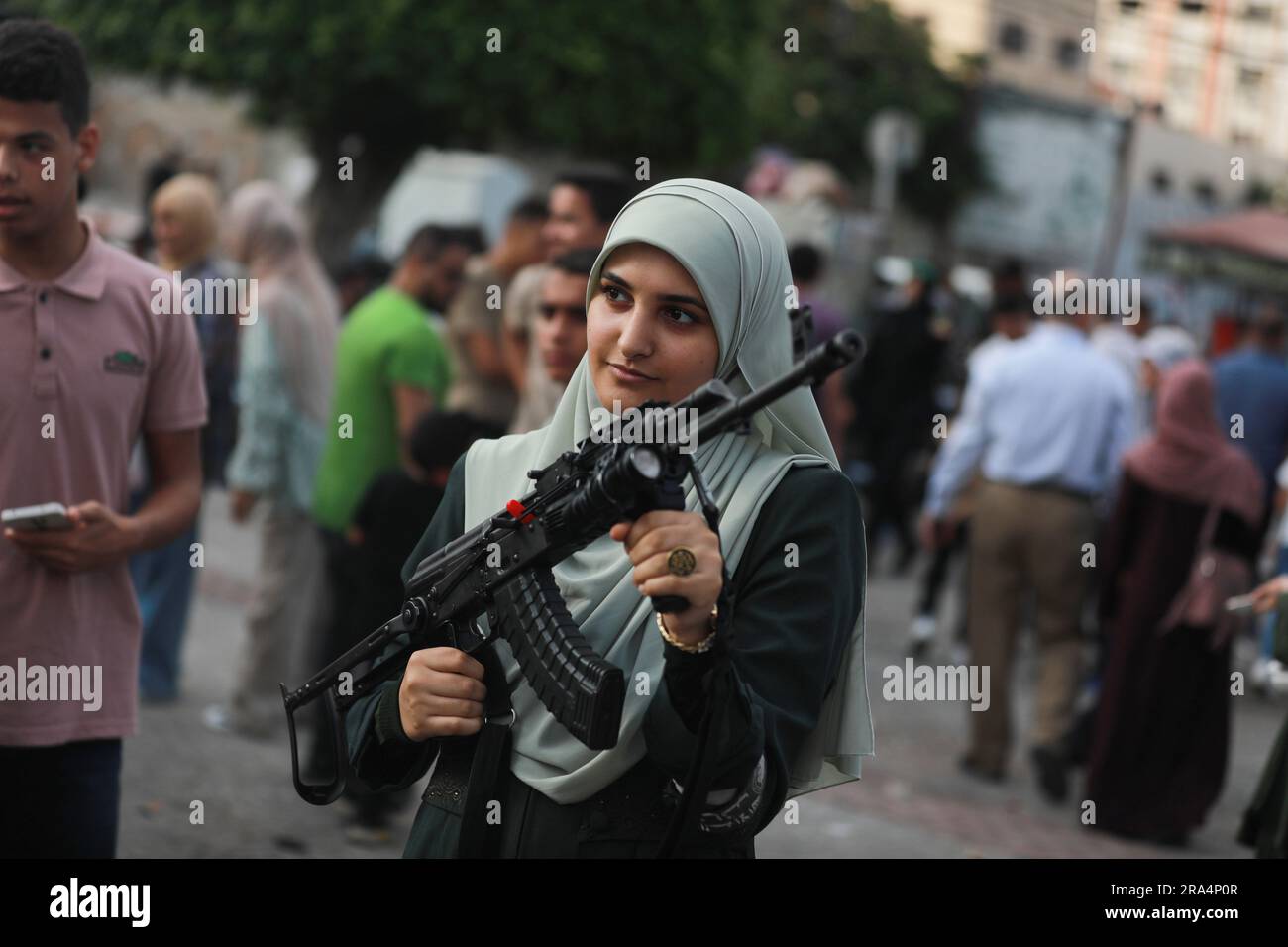 A Palestinian woman carries a machine gun as she attends a military ...