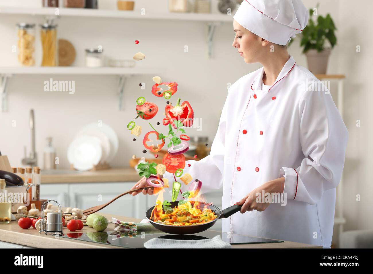 Female chef frying vegetables in kitchen Stock Photo - Alamy
