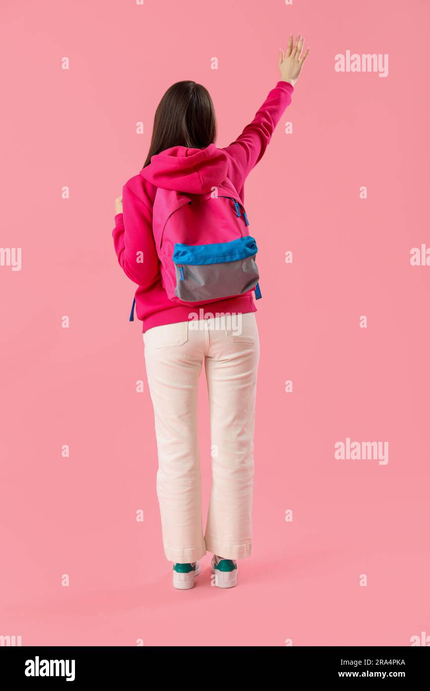 Female student with backpack on pink background, back view Stock Photo ...
