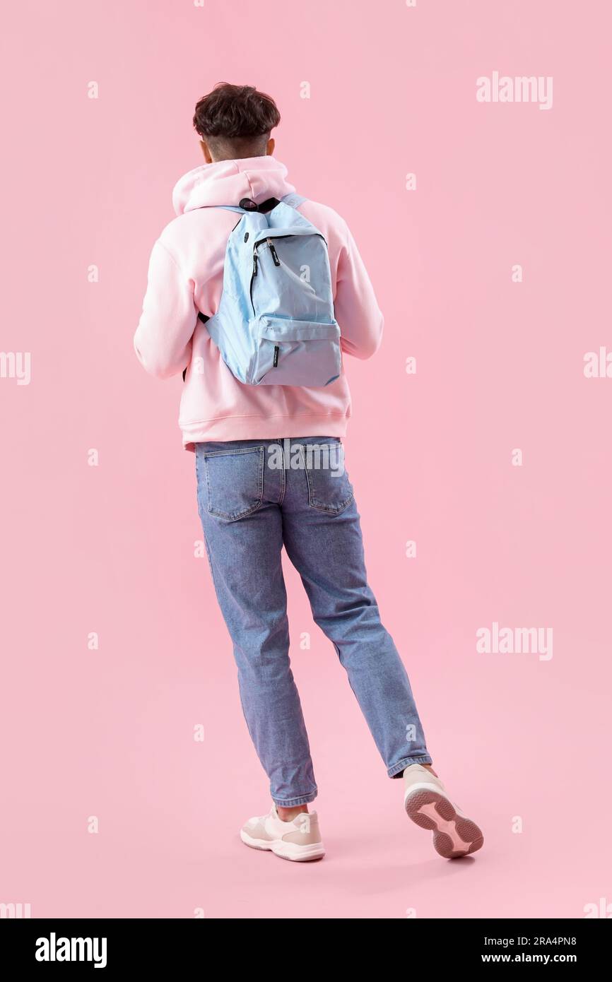 Male student with backpack on pink background, back view Stock Photo ...