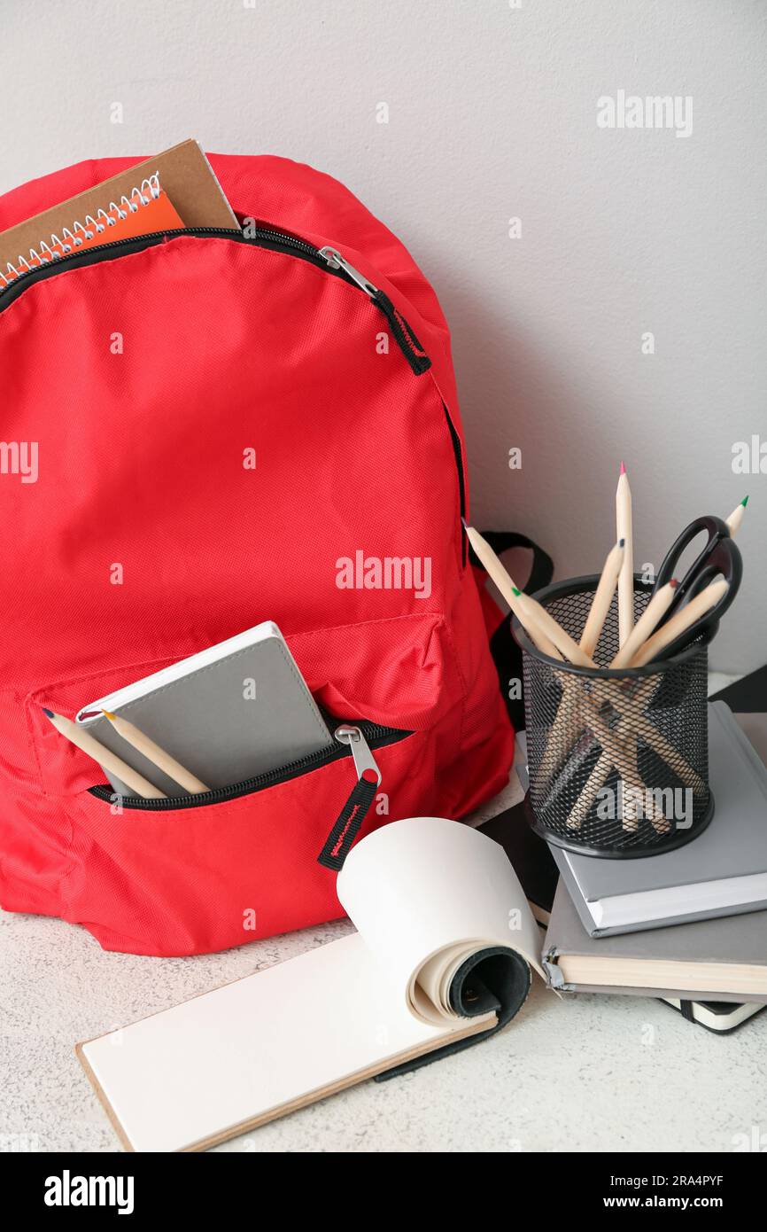 Red school backpack with notebooks, color pencils and scissors on white ...