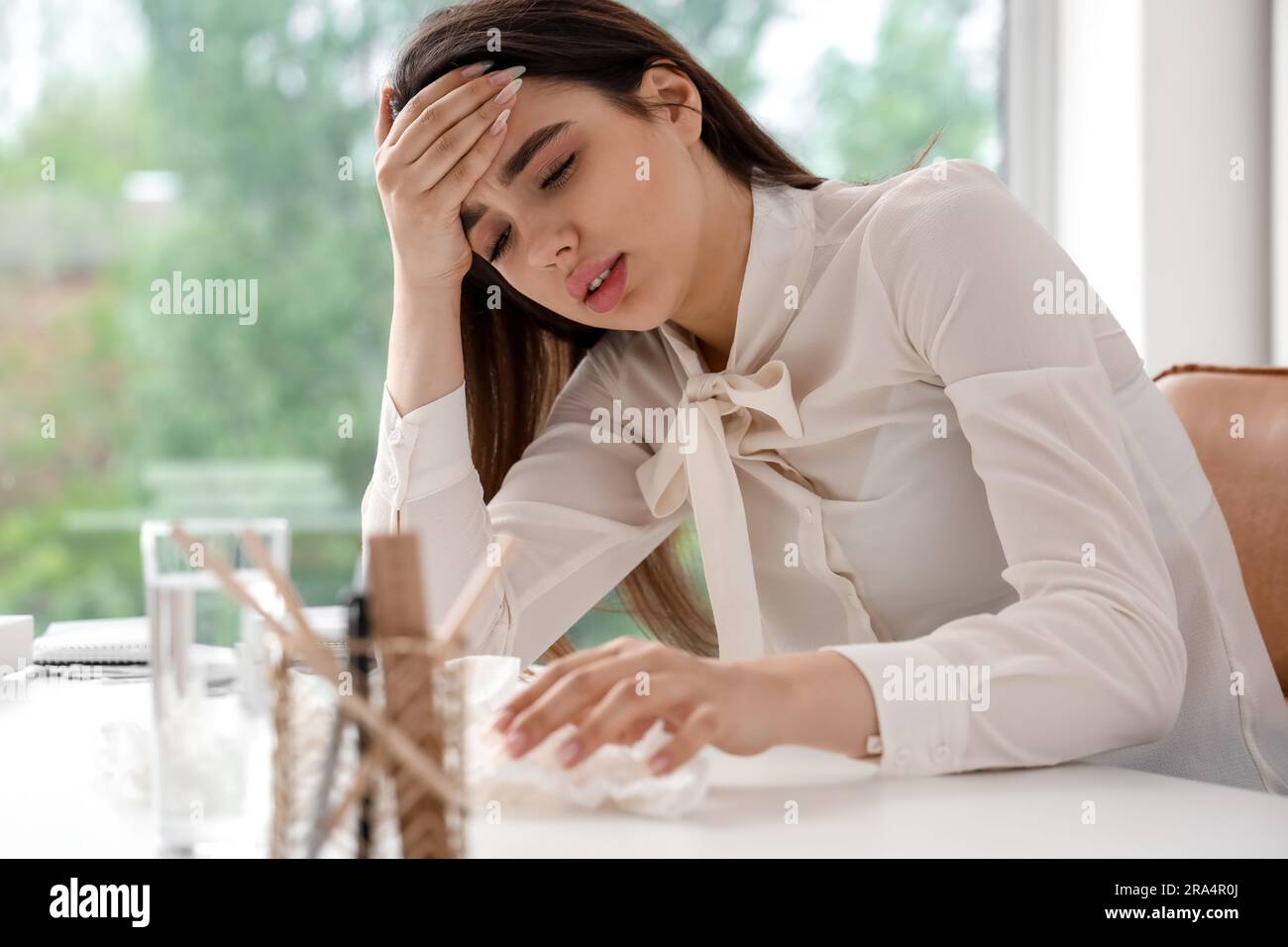 Sick woman at workplace in office Stock Photo - Alamy