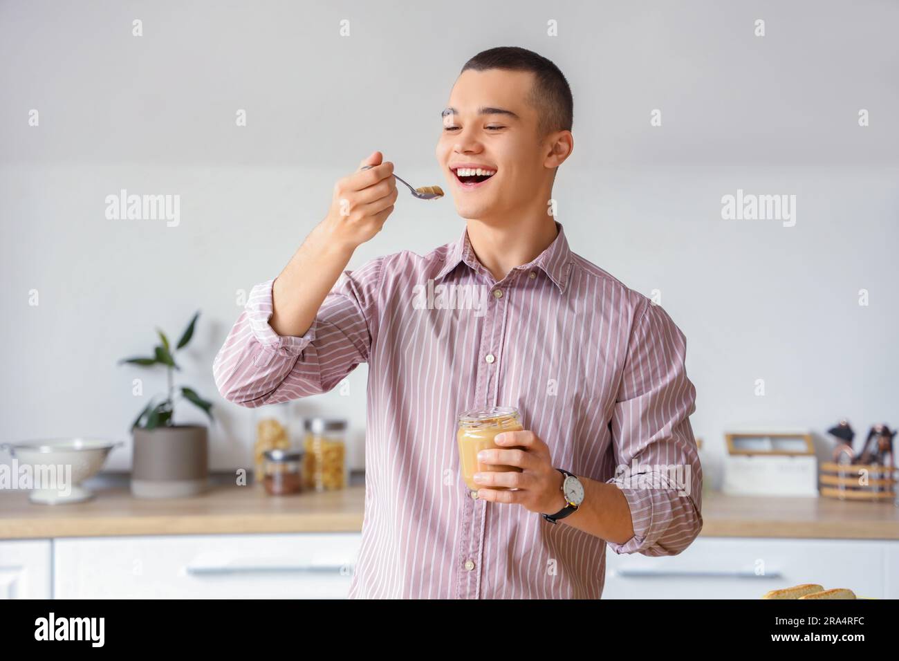 Young man eating peanut butter hi-res stock photography and images - Alamy