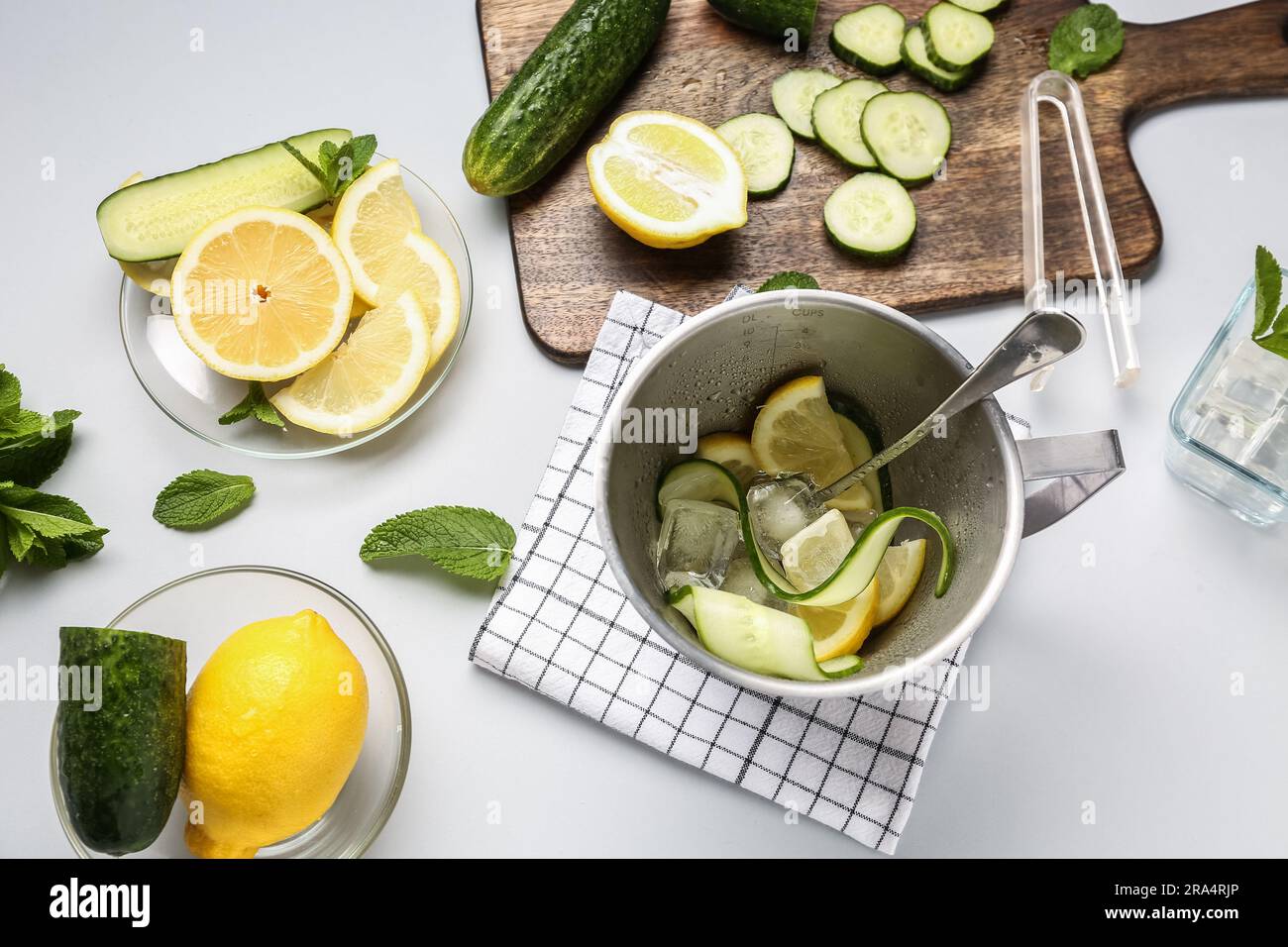 Bucket and bowls with ingredients for preparing cucumber lemonade on ...