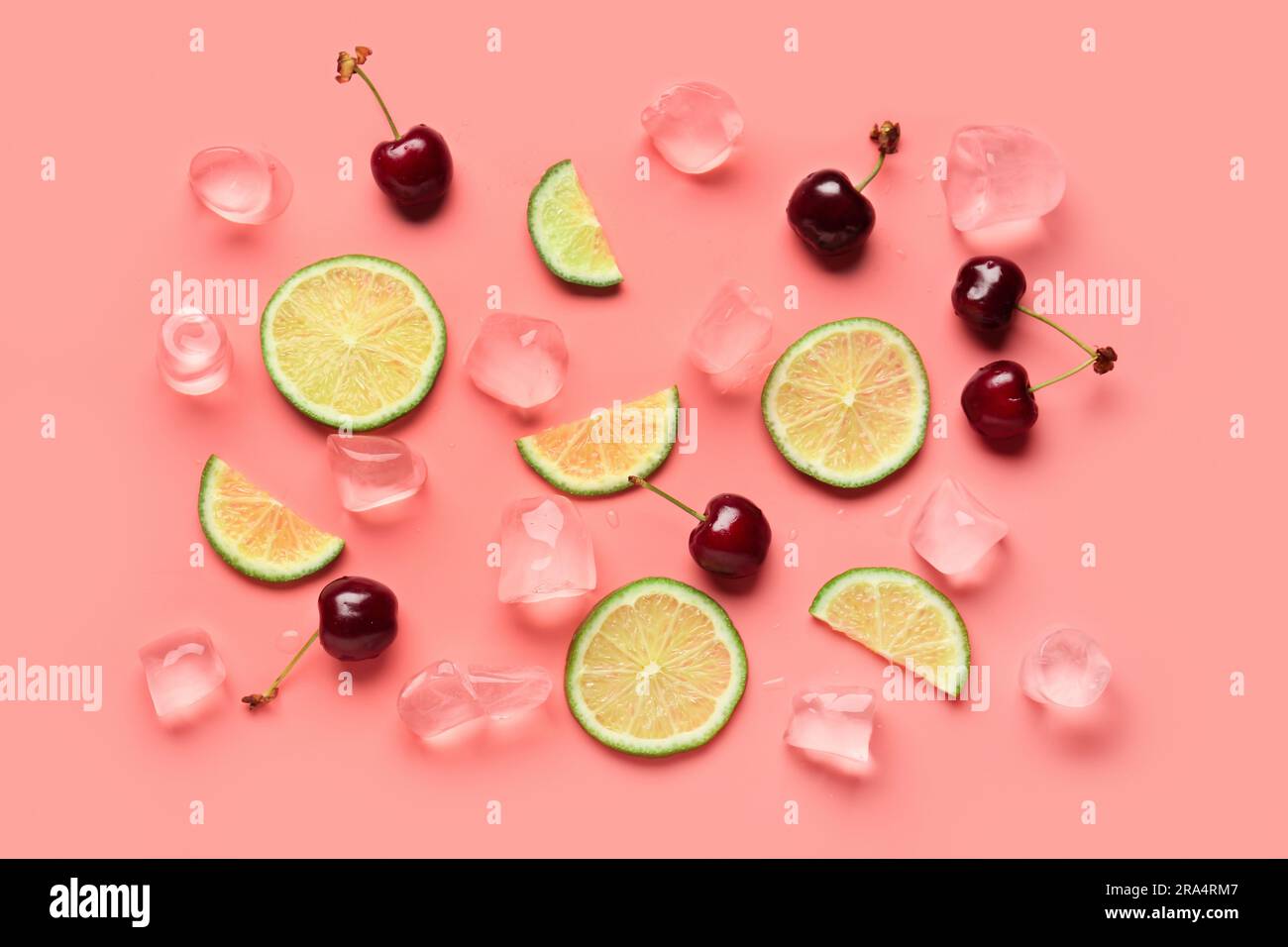 Lime slices with cherries and ice cubes on pink background Stock Photo ...