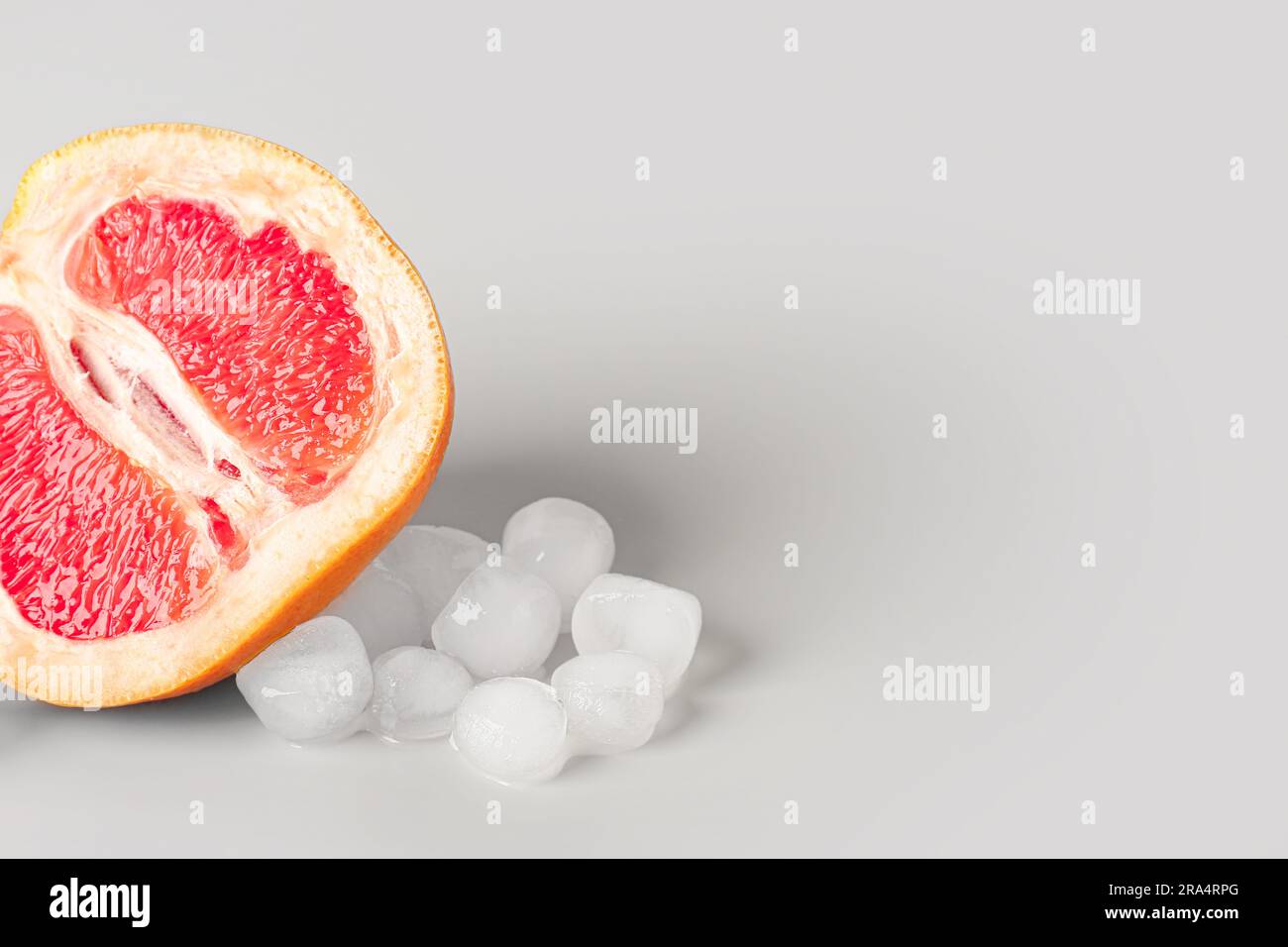 Grapefruit with ice cubes on grey background Stock Photo - Alamy