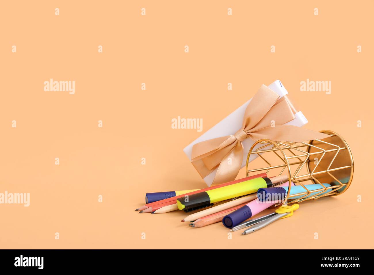 Gift box with stationery holder on pale orange background Stock Photo ...
