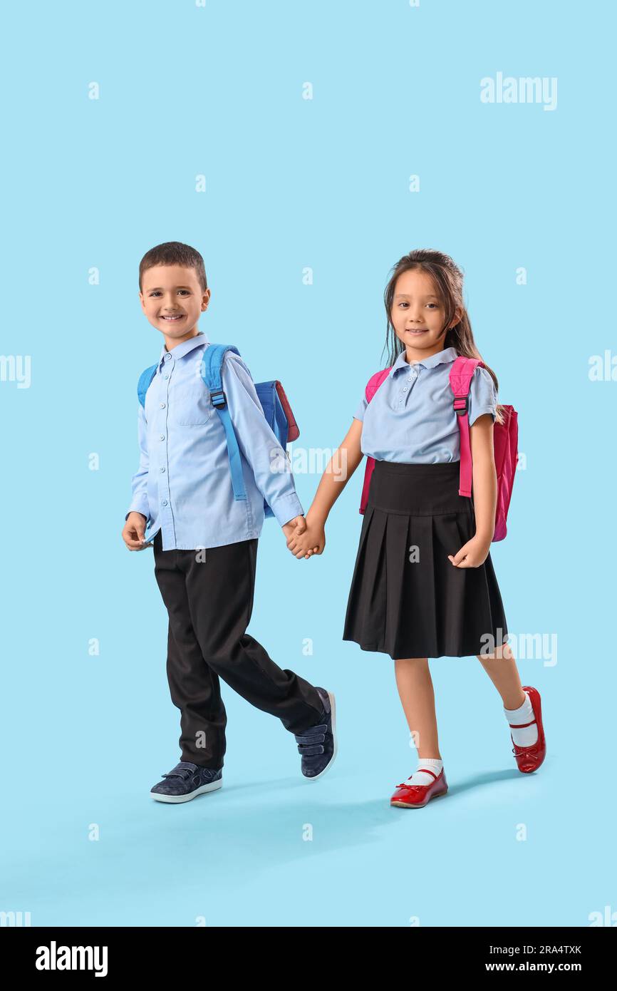 Little schoolchildren holding hands on light blue background Stock ...