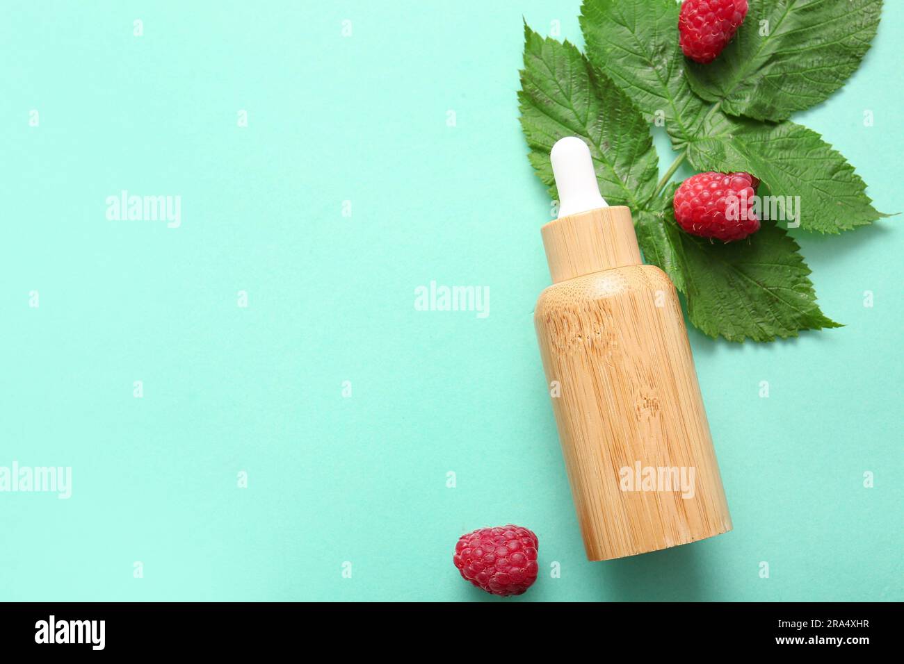 Bottle of cosmetic raspberry oil on blue background Stock Photo - Alamy