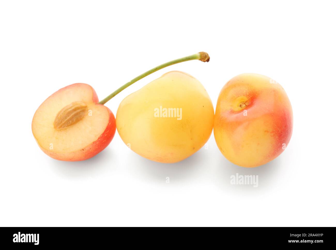 Sweet yellow cherries with half on white background Stock Photo - Alamy