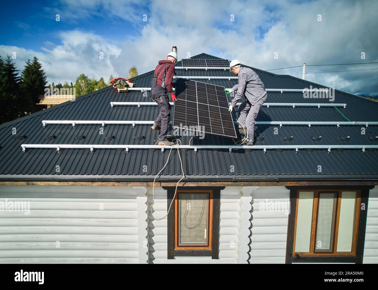 Male workers installing solar cell on a roof. Solar system installation ...