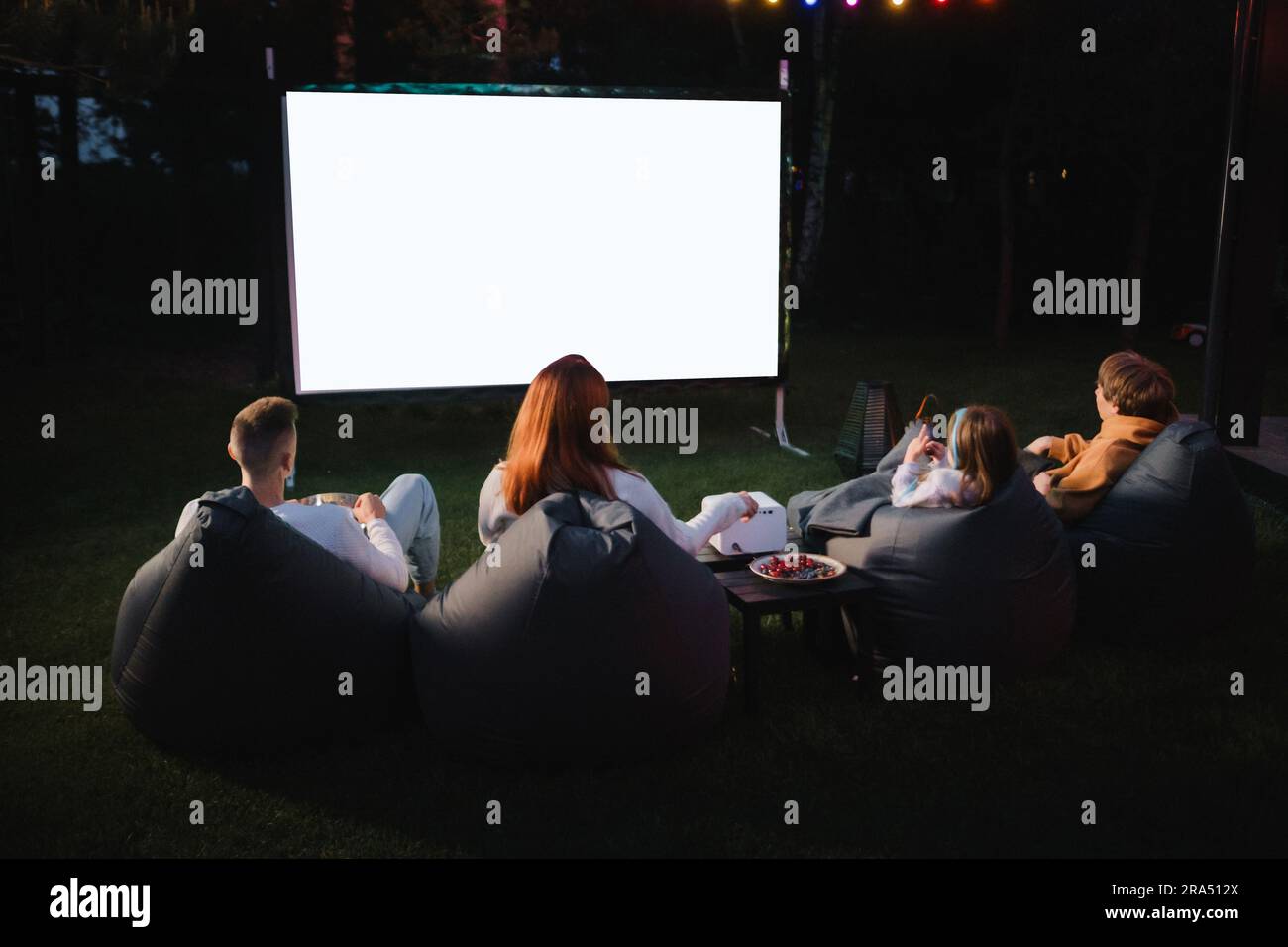 family mother, father and children watch a projector, movies with ...