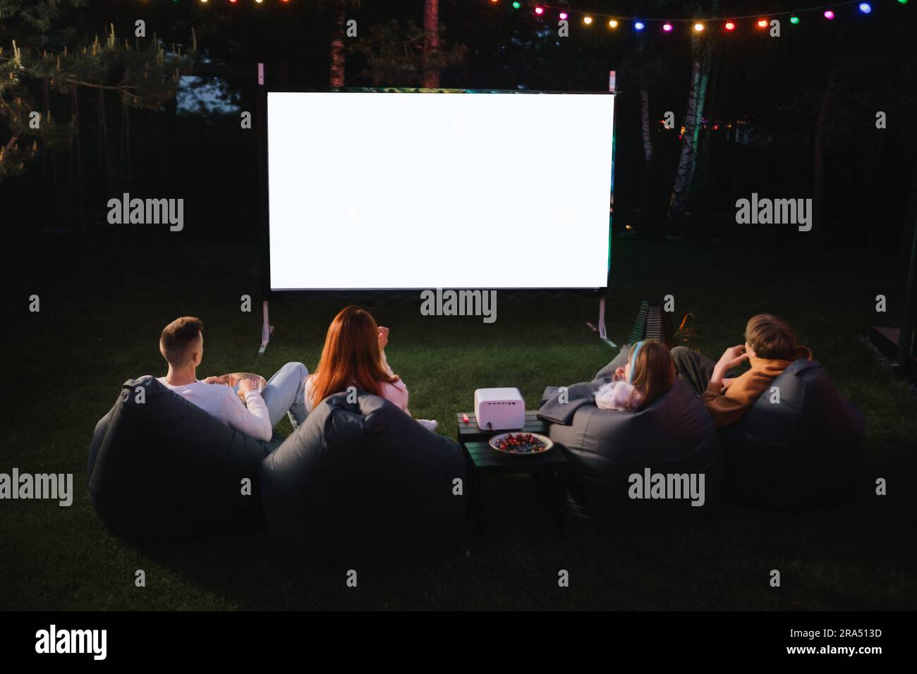 family mother, father and children watch a projector, movies with ...