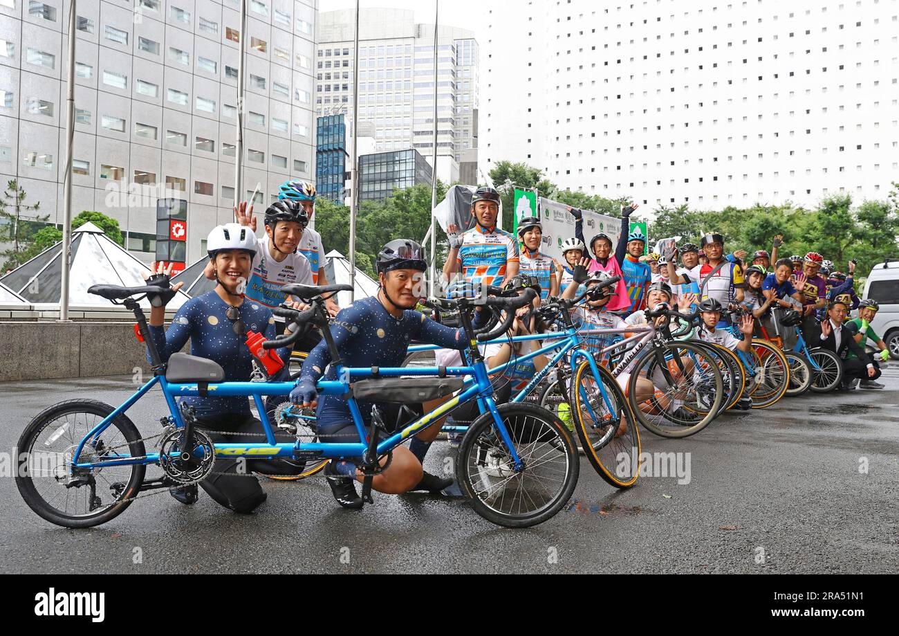 Riders of a tandem bicycle pose before running on a public road during ...