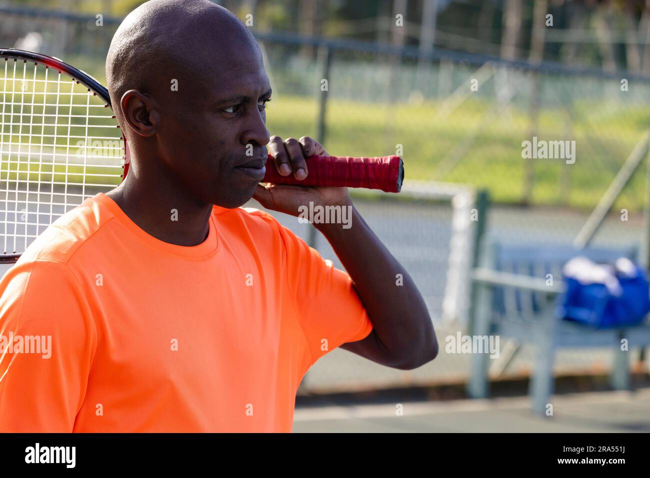 Focused african american male tennis player holding tennis racket on ...
