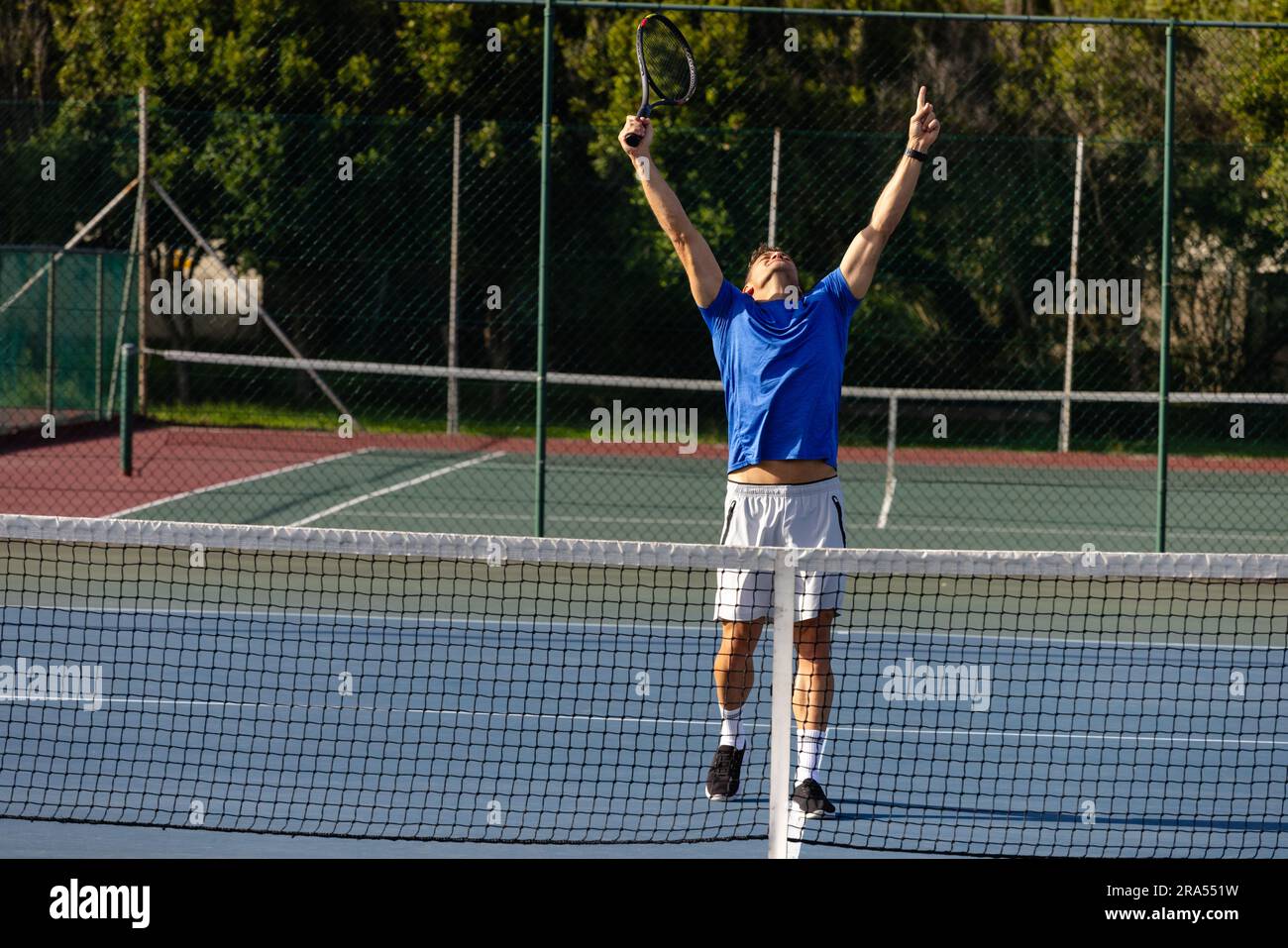 Happy caucasian male tennis player celebrating victory and raising ...