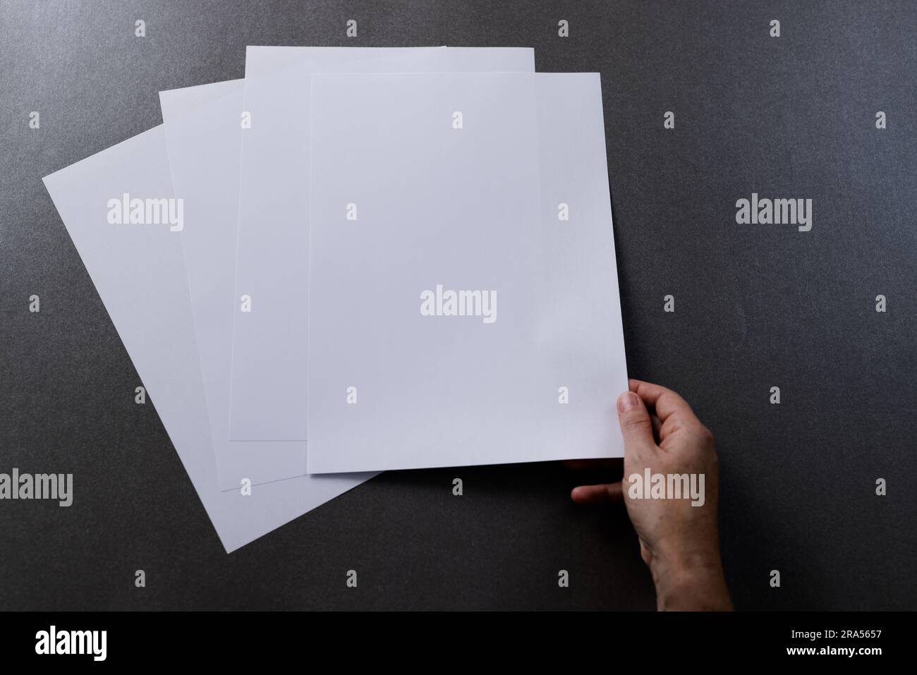 Hand of caucasian woman holding piece of paper over paper pieces with ...