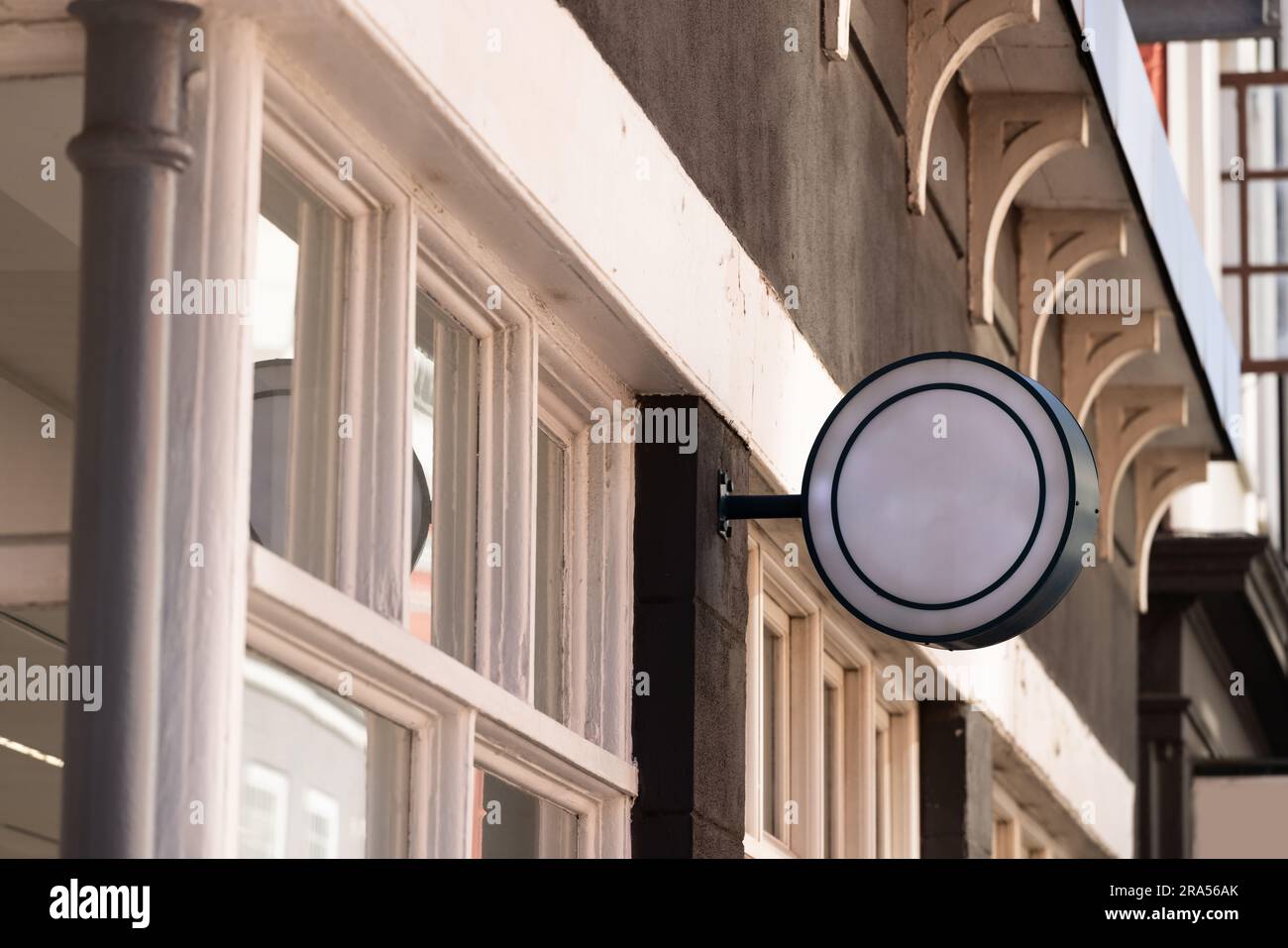 Blank round sign fixed to building wall with copy space Stock Photo - Alamy