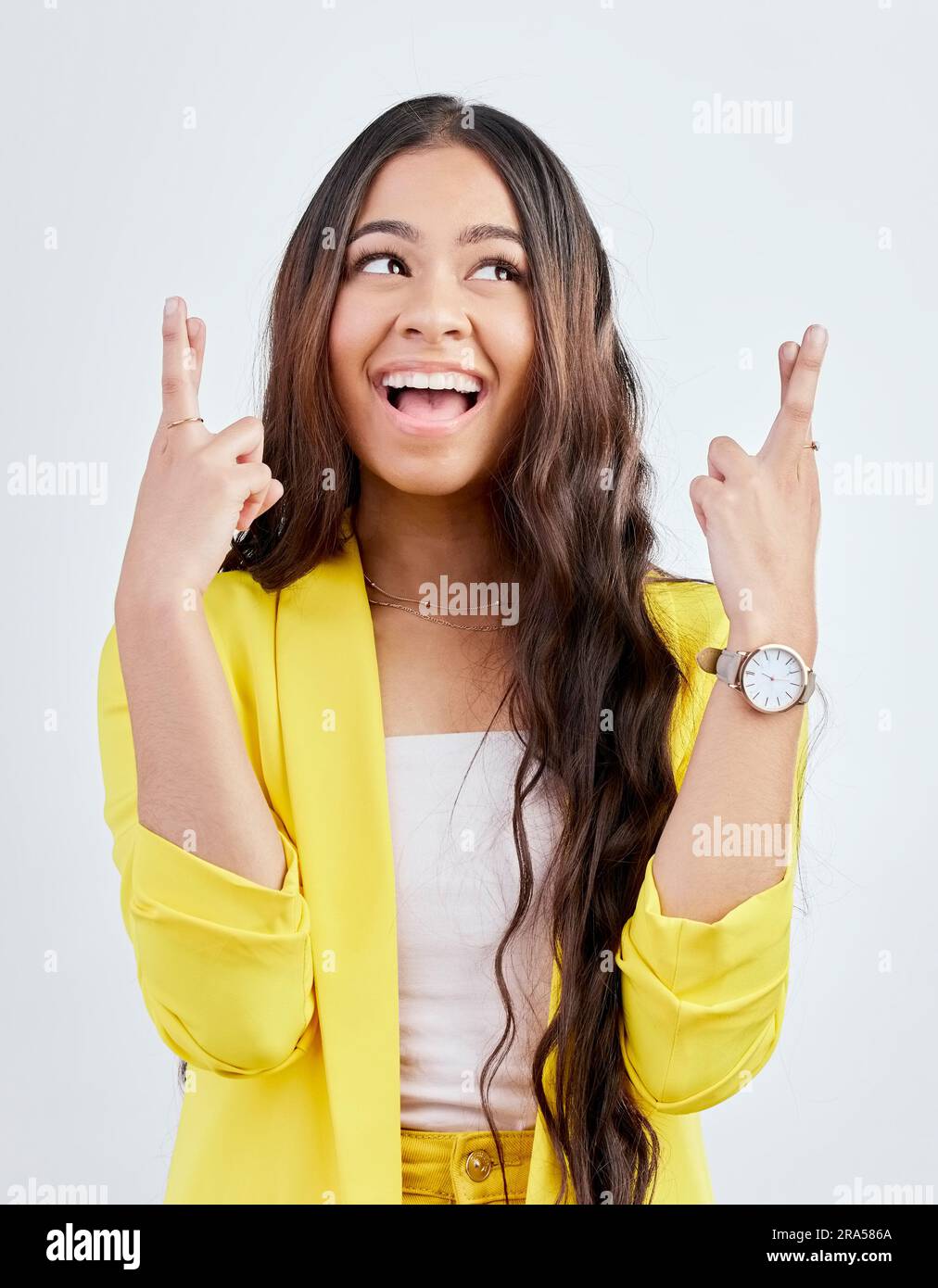 Hope, fingers crossed and face of woman in studio with hand gesture for ...
