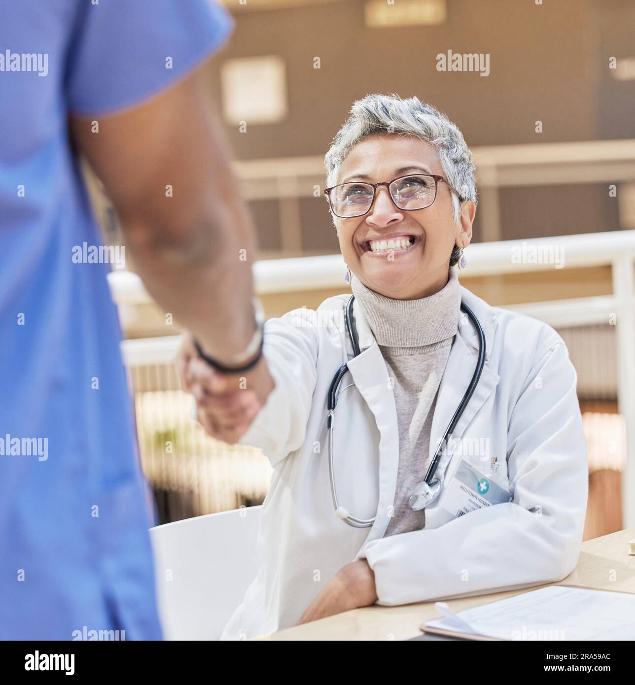 Senior doctor, handshake and introduction, thank you and ...