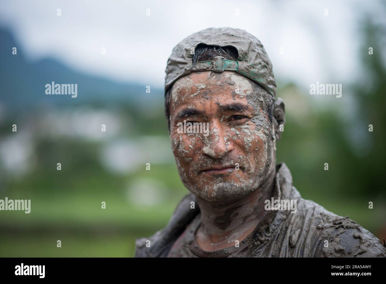 Kathmandu, Nepal. 30th June, 2023. A man's face covered with mud smiles ...