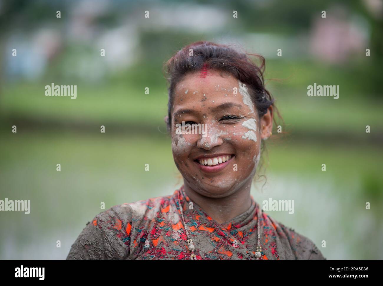 Kathmandu, Nepal. 30th June, 2023. A woman covered in mud smiles at a ...