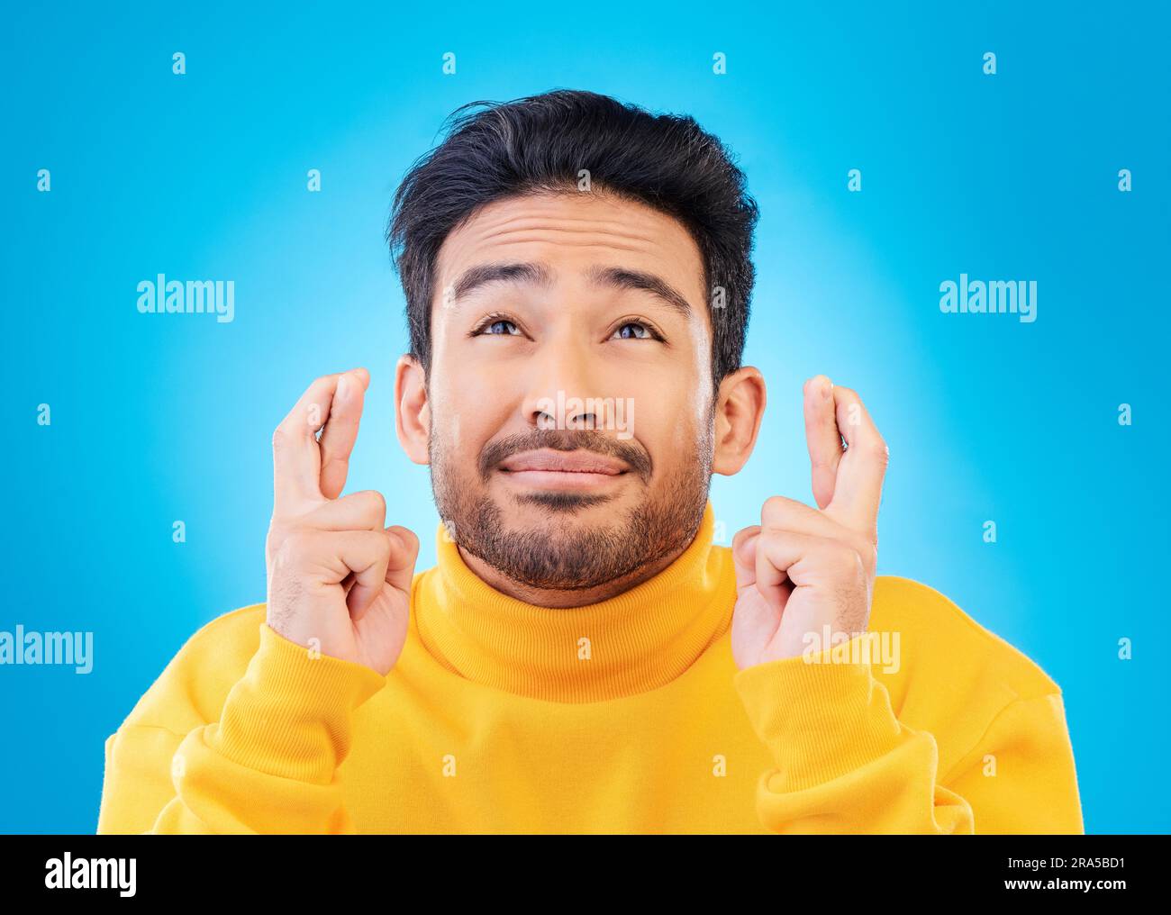 Hope, man with his fingers crossed for luck and against a blue ...