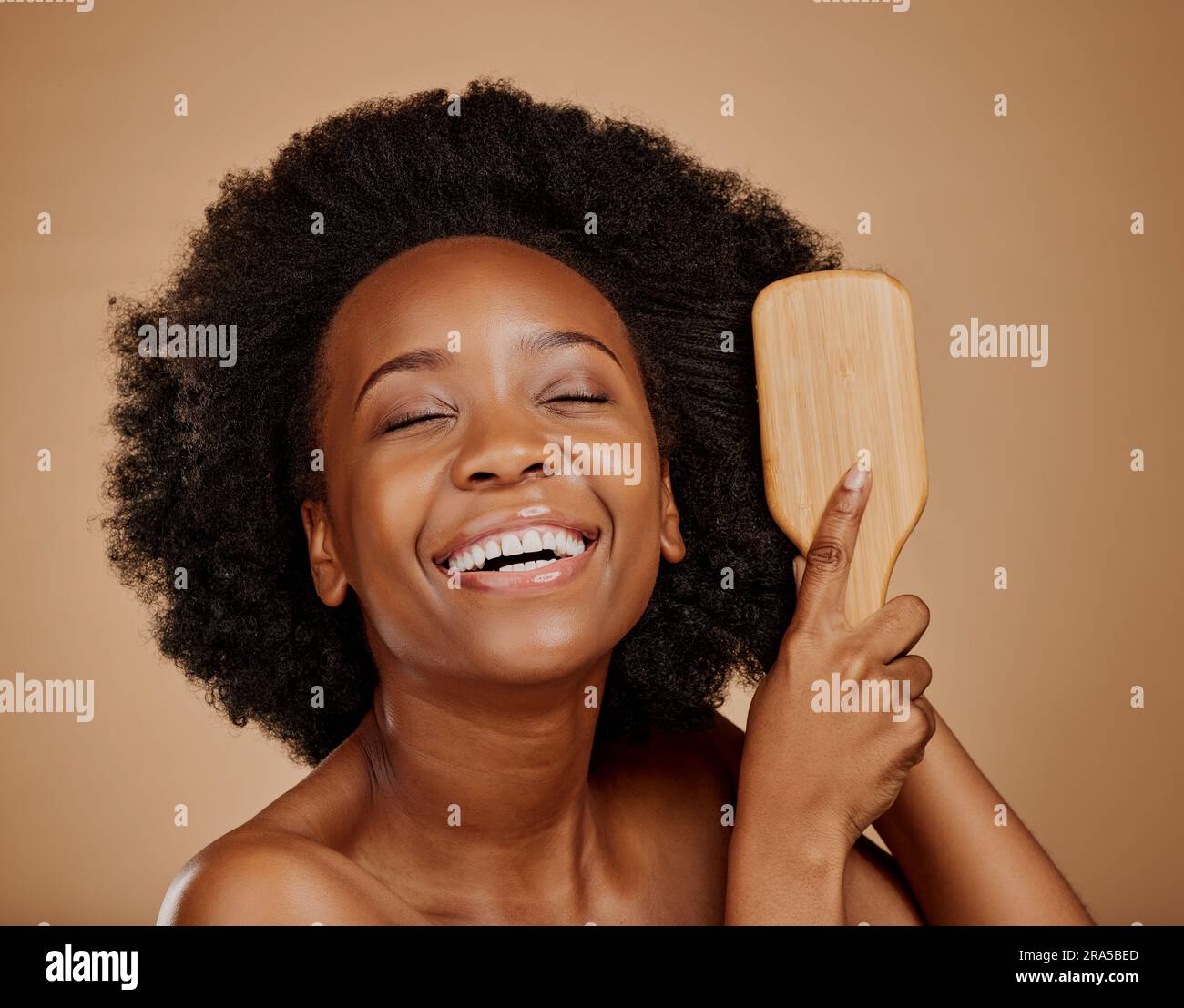 Happy black woman, brush and hair care in studio, brown background and ...