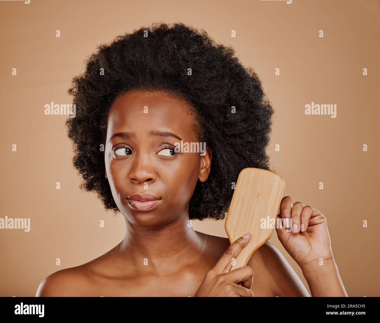 Sad black woman, hair and unhappy with brush in studio, brown ...