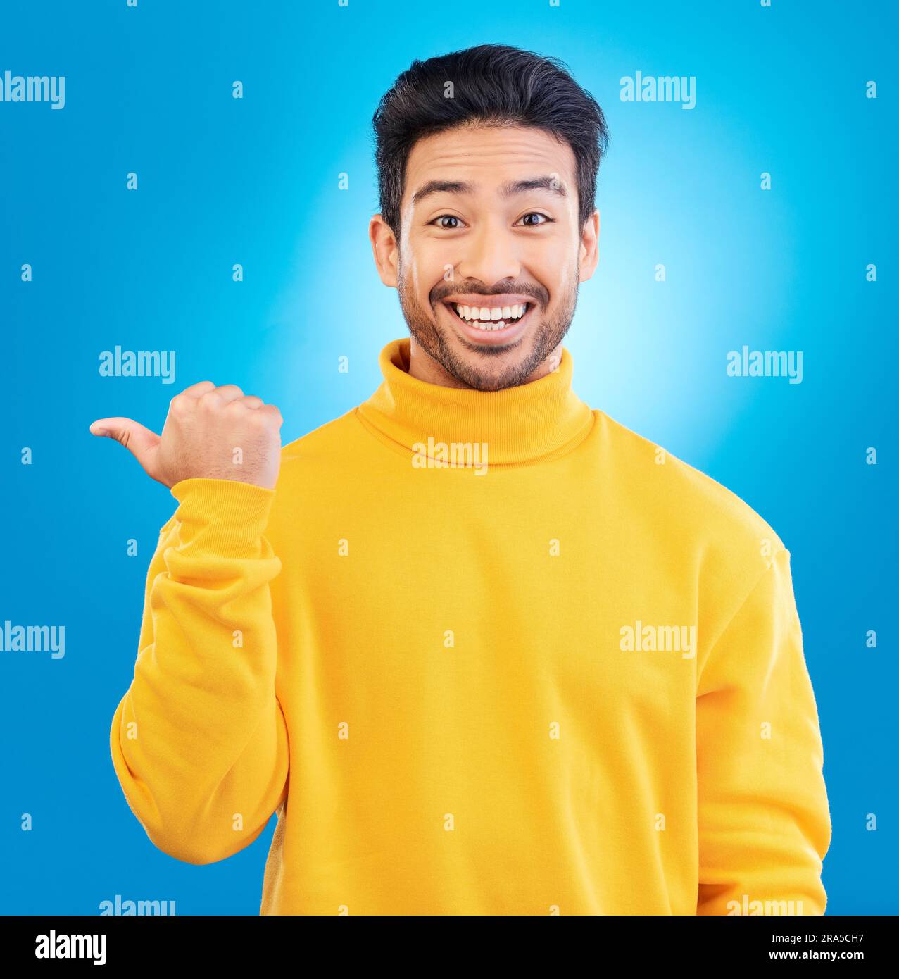 Portrait, man and pointing to advertising space in studio, blue ...
