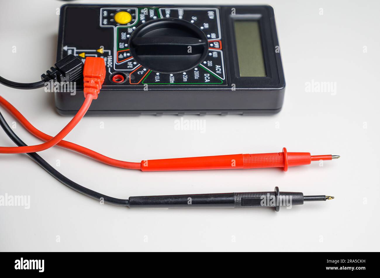 Digital multimeter with test leads on a white table. A multimeter is an ...