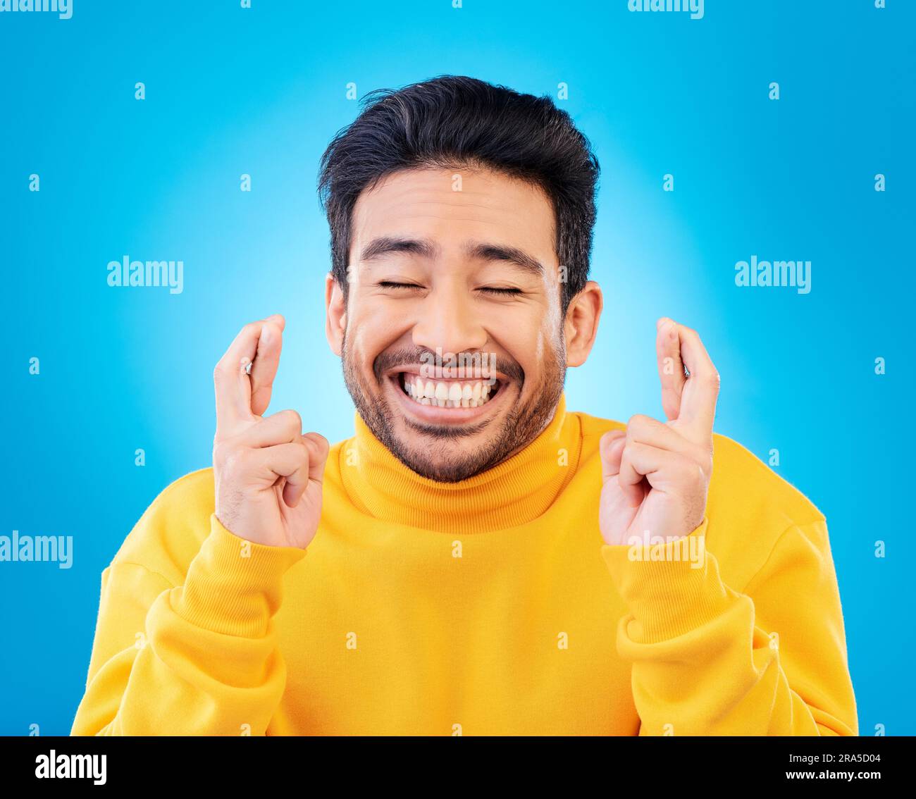 Hope, man with his fingers crossed for luck and against a blue ...