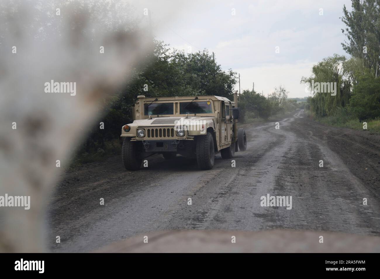 A Ukrainian military vehicle HMMWV travels on the road at the front ...