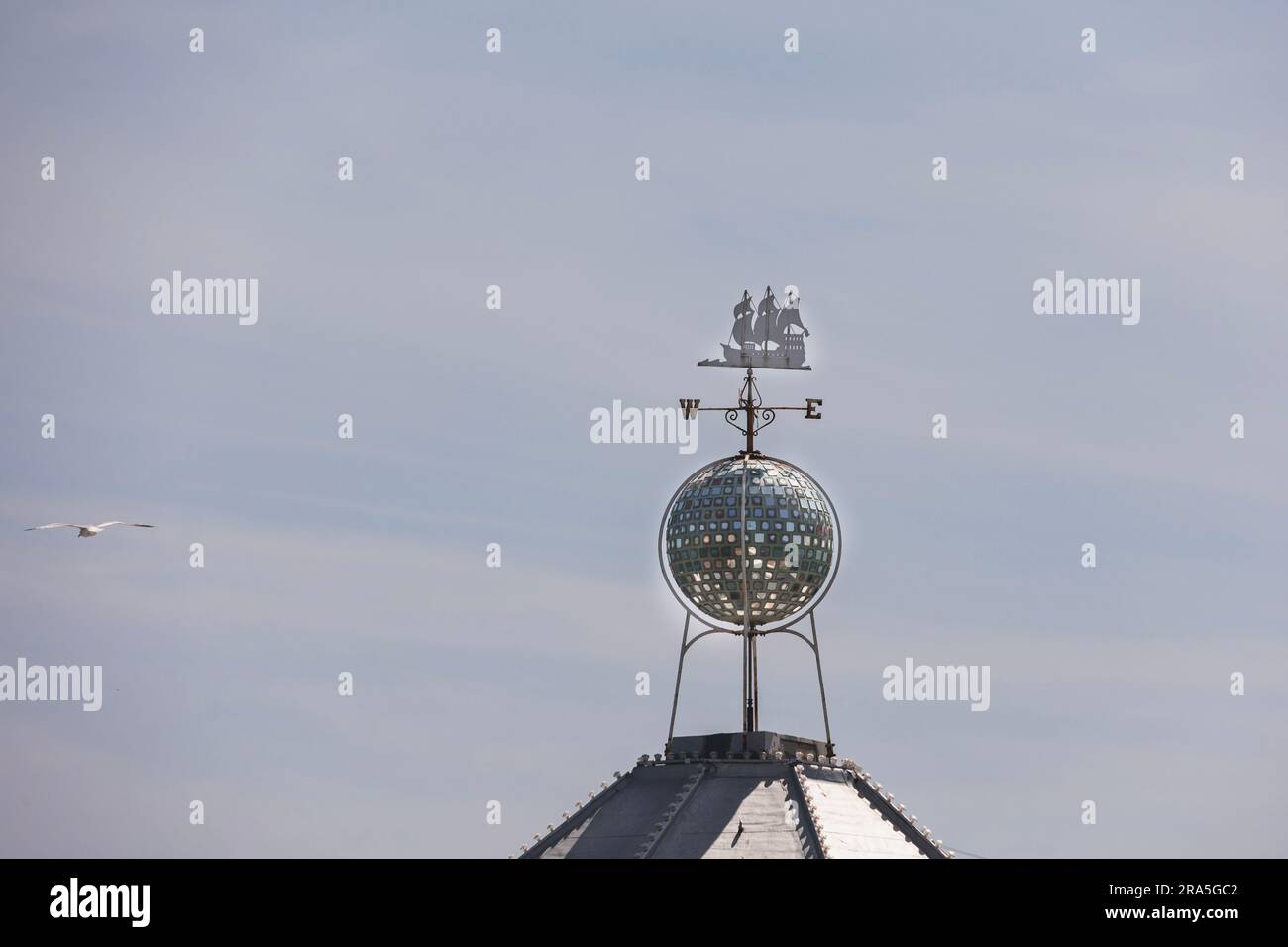 decorative compass showing a metal ship and directions on a rood top on ...