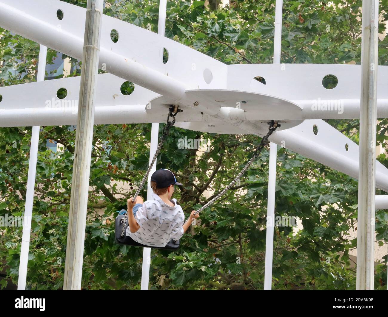 London, UK - June 2023 : A boy playing on the swing inside the giant 9 ...