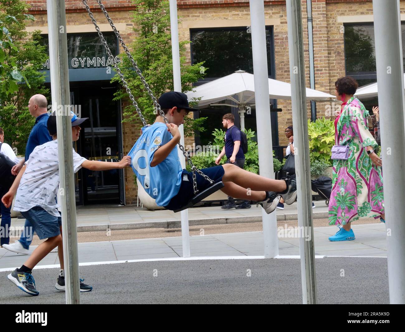 London, UK - June 2023 : Boys playing on the swing inside the giant 9 ...
