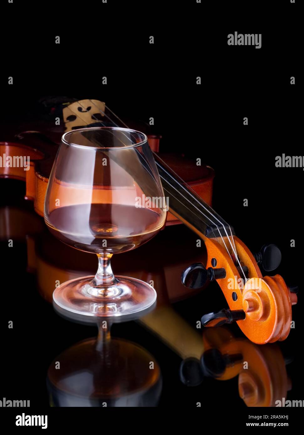 Snifter glass of cognac and violin Stock Photo - Alamy