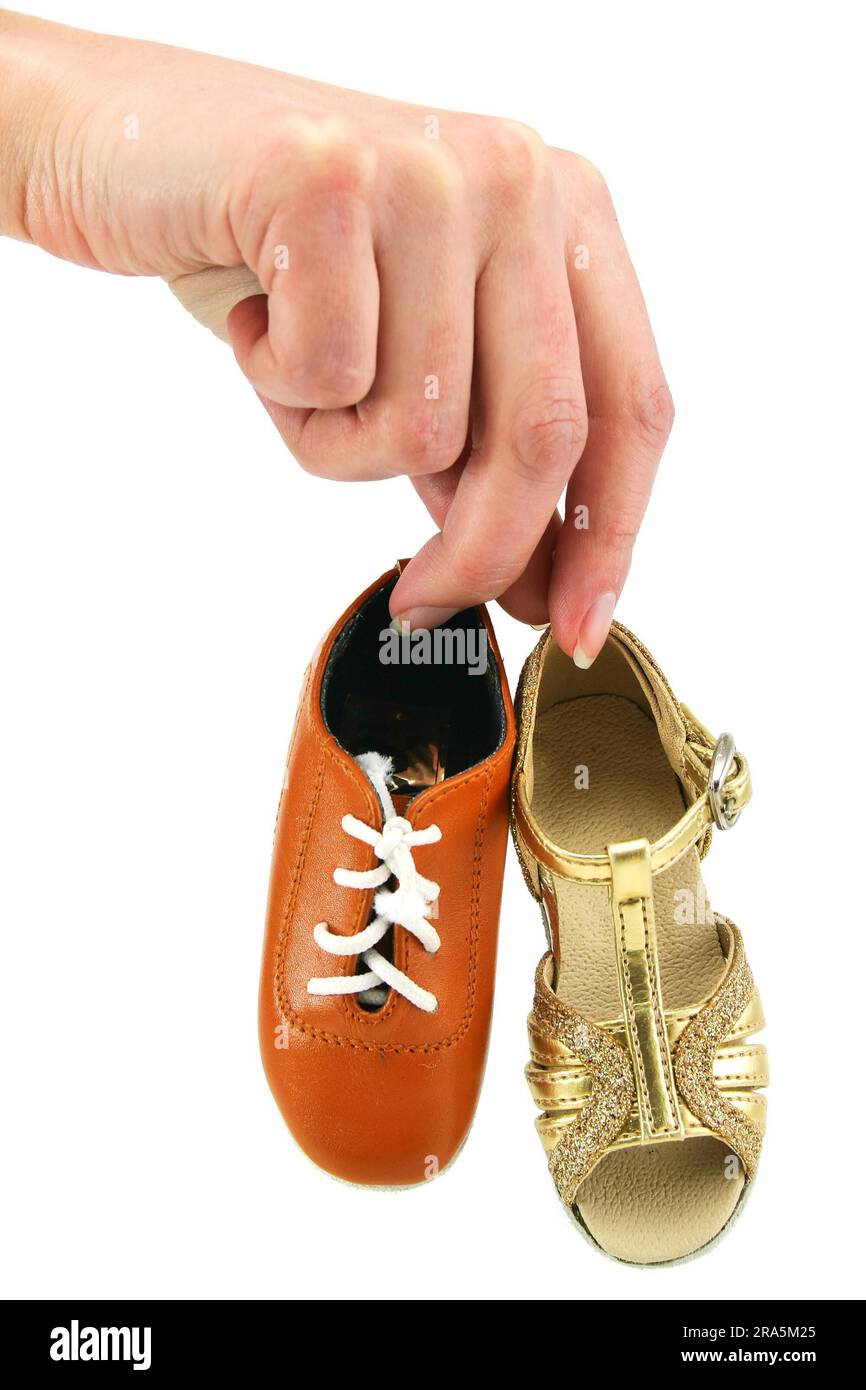 Female hand holds tiny dancing shoes (men's and woman's) isolated on a ...