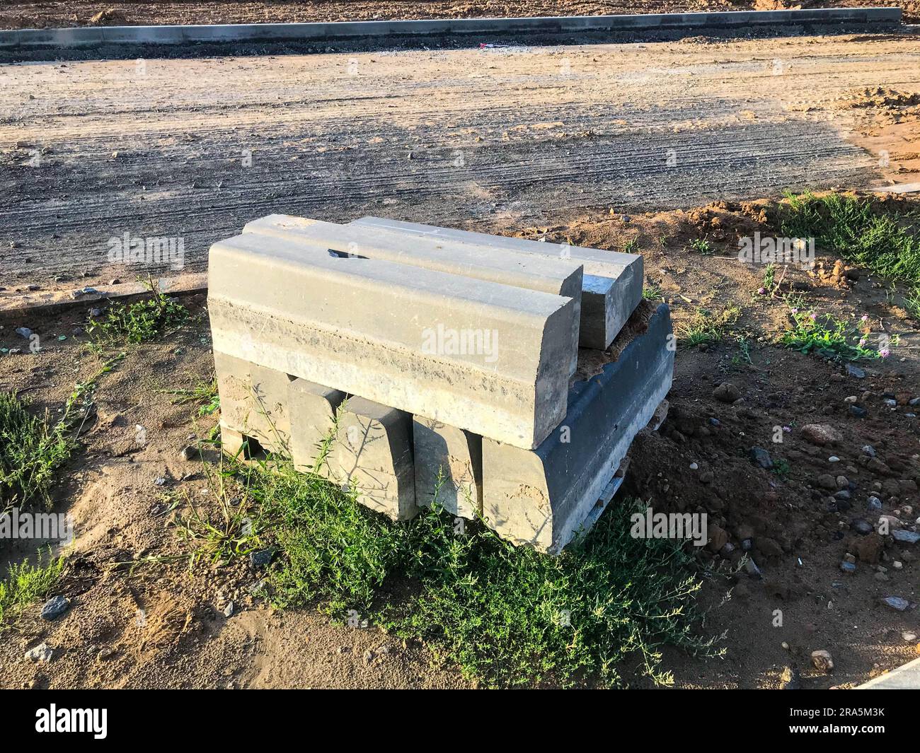 concrete blocks lie on brown soil and lawn. concrete is used for the ...