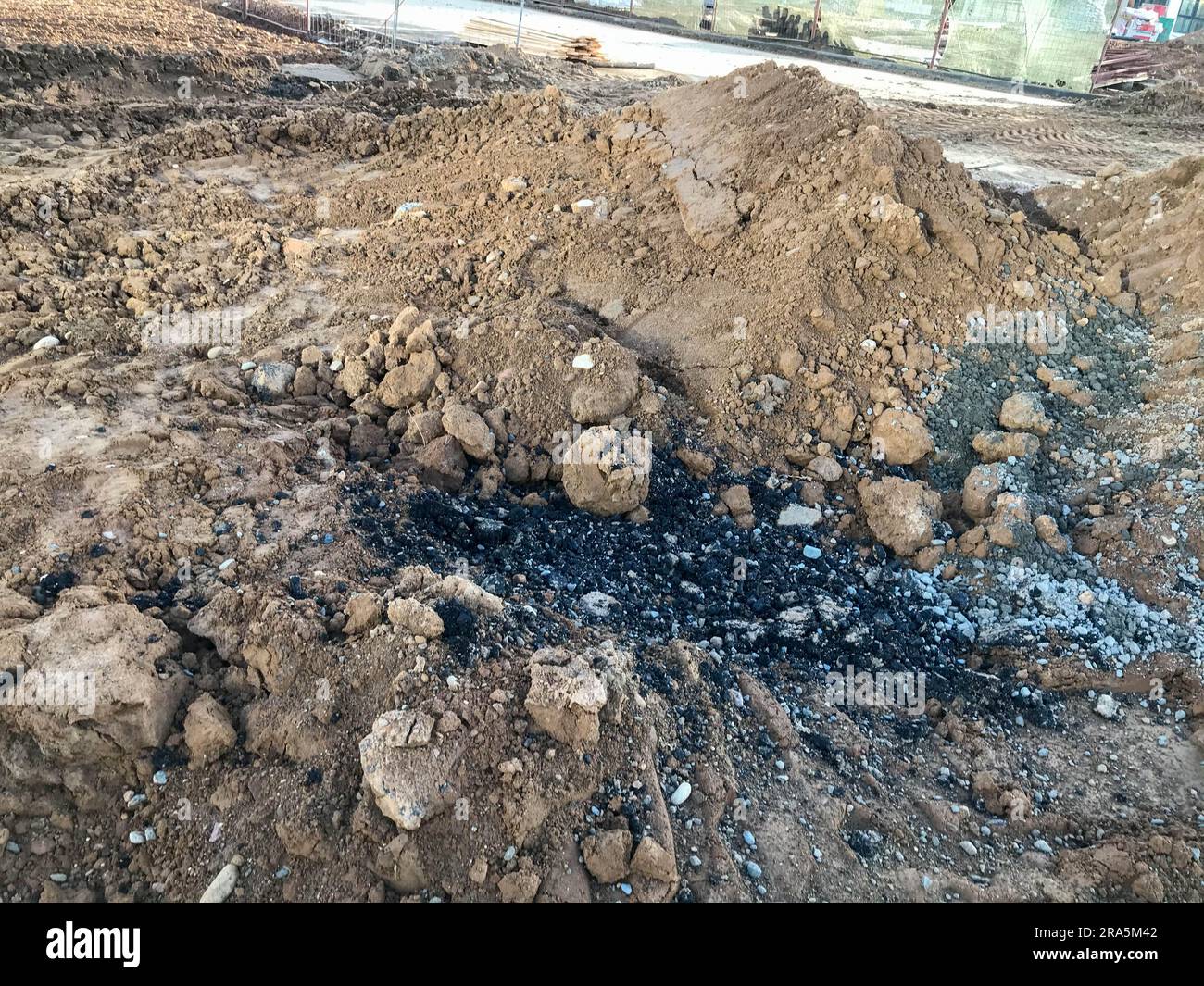 a pile of sand piled up at a construction site. black and viscous fuel ...